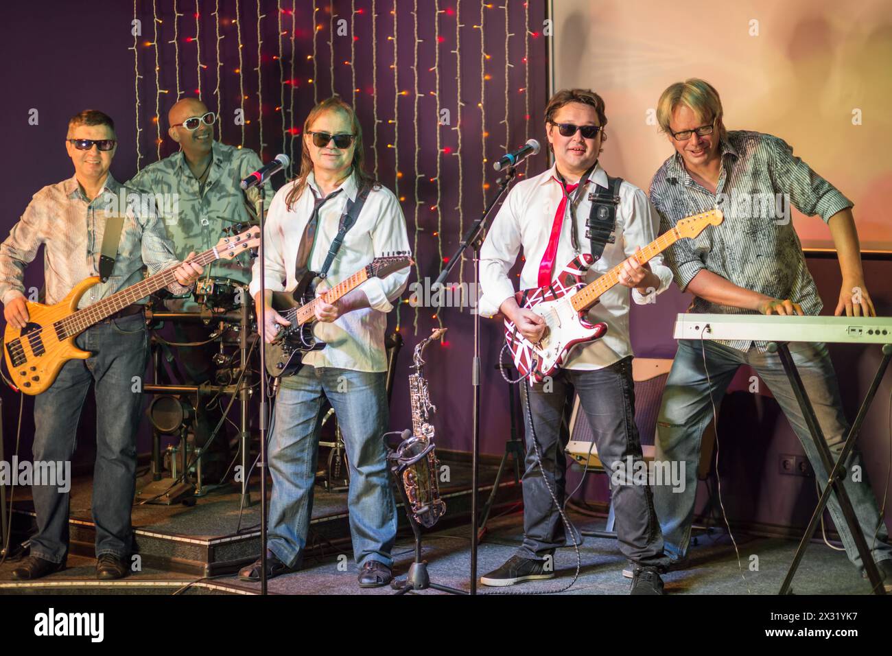 The musical group of five men with with musical instruments performs on ...