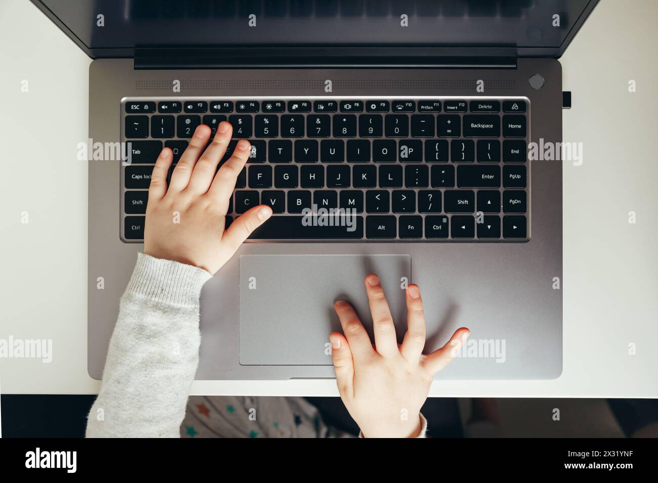 Child's hand on laptop computer keyboard. Access to information ...