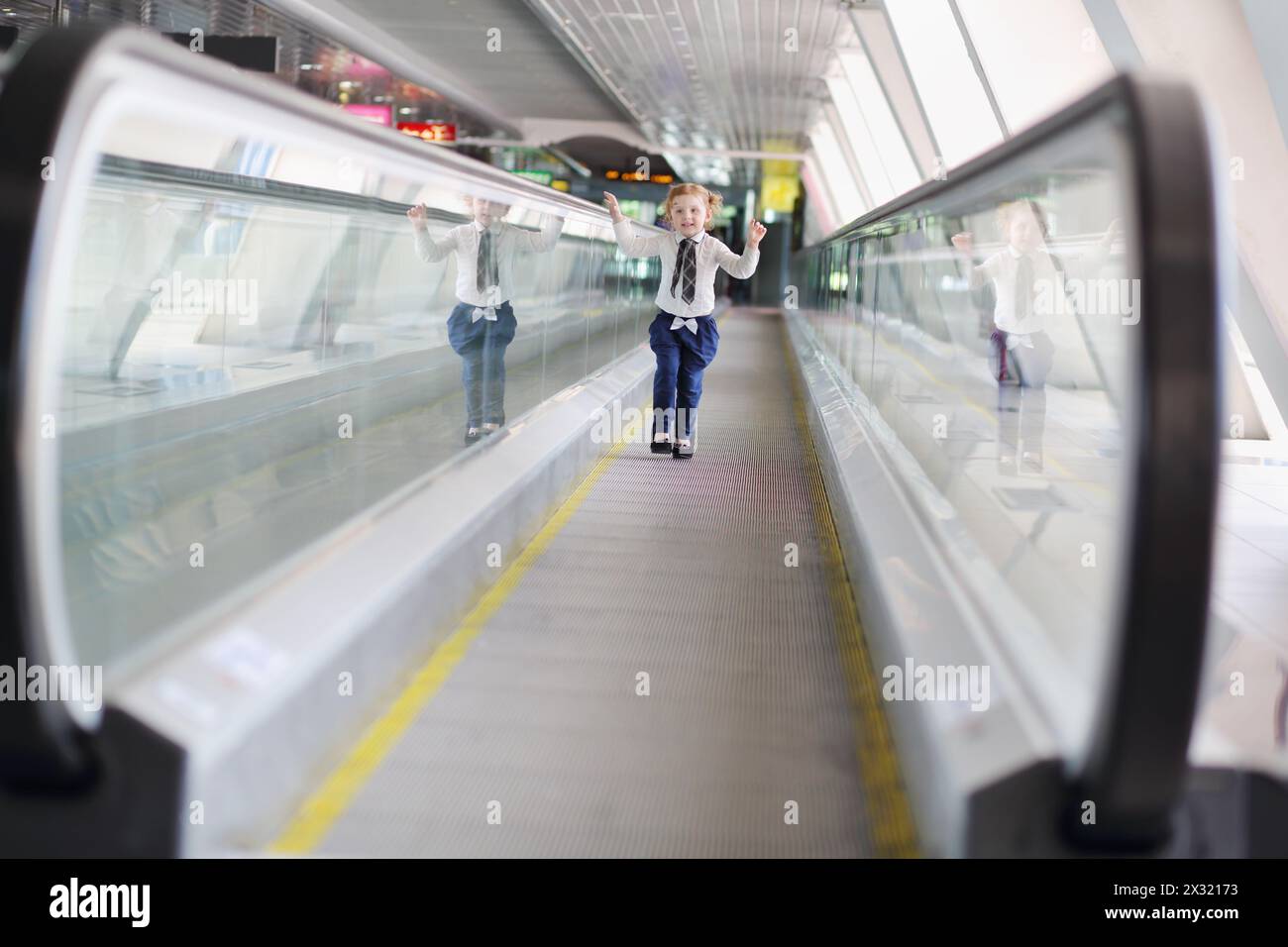 Little happy cute girl in mother shoes walks at long travelator Stock ...