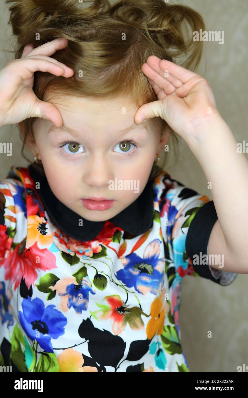 A little girl raised her eyebrows fingers Stock Photo - Alamy