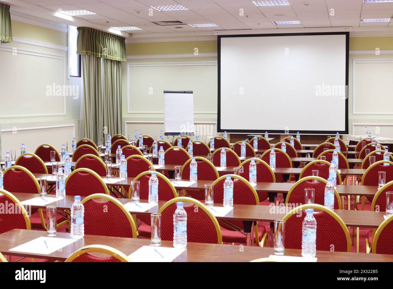 Back of red chairs and wooden tables with bottles and glasses in simple ...