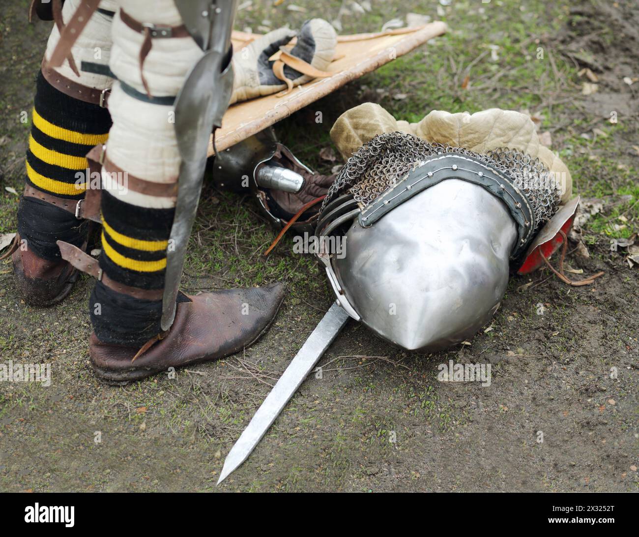 Legs of man and armored metal medieval helmet on ground outdoor Stock ...