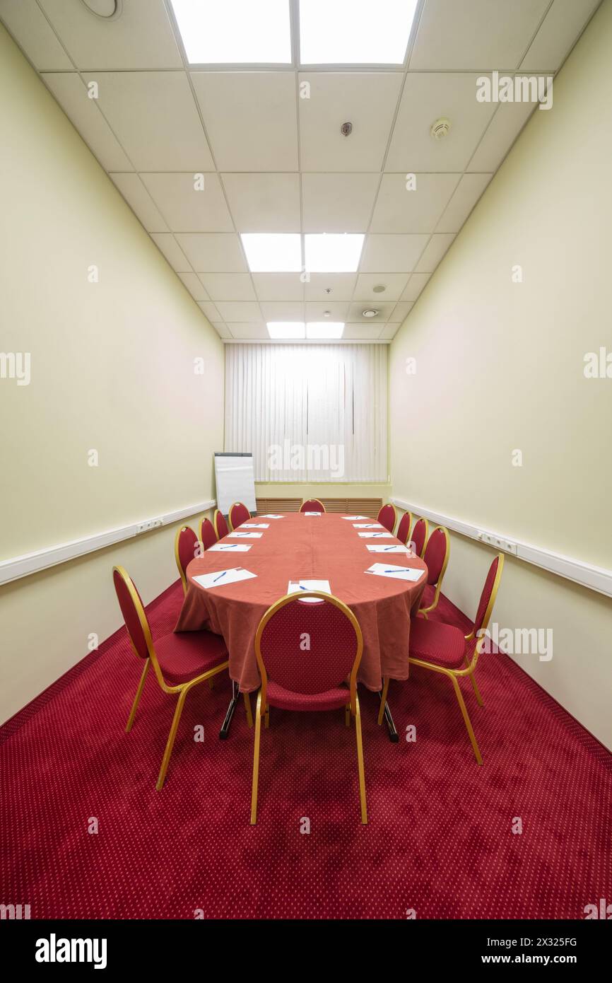 Chairs and table in empty conference room with a red carpet on the ...