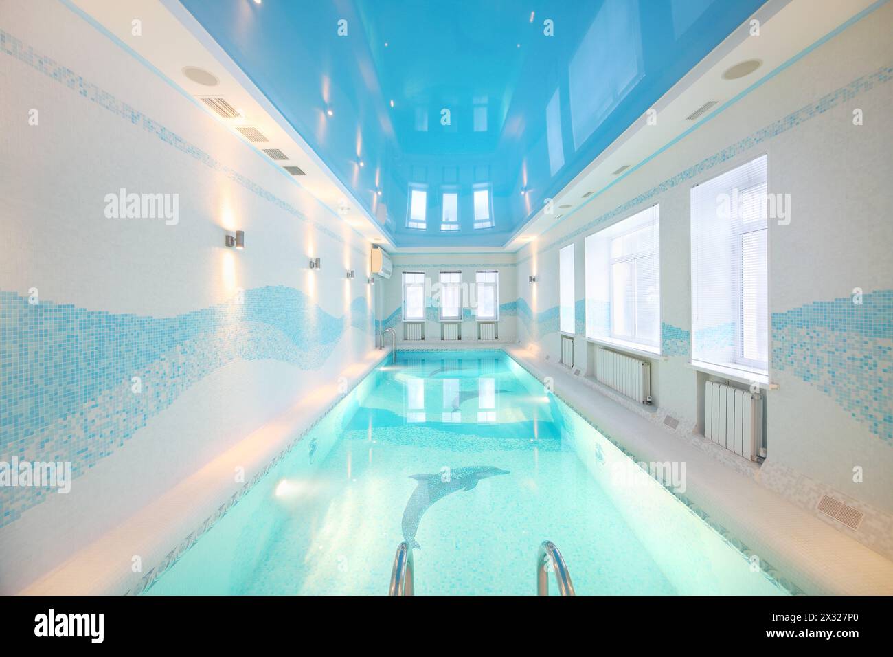 Beautiful clean pool with images of dolphins at bottom in big room ...