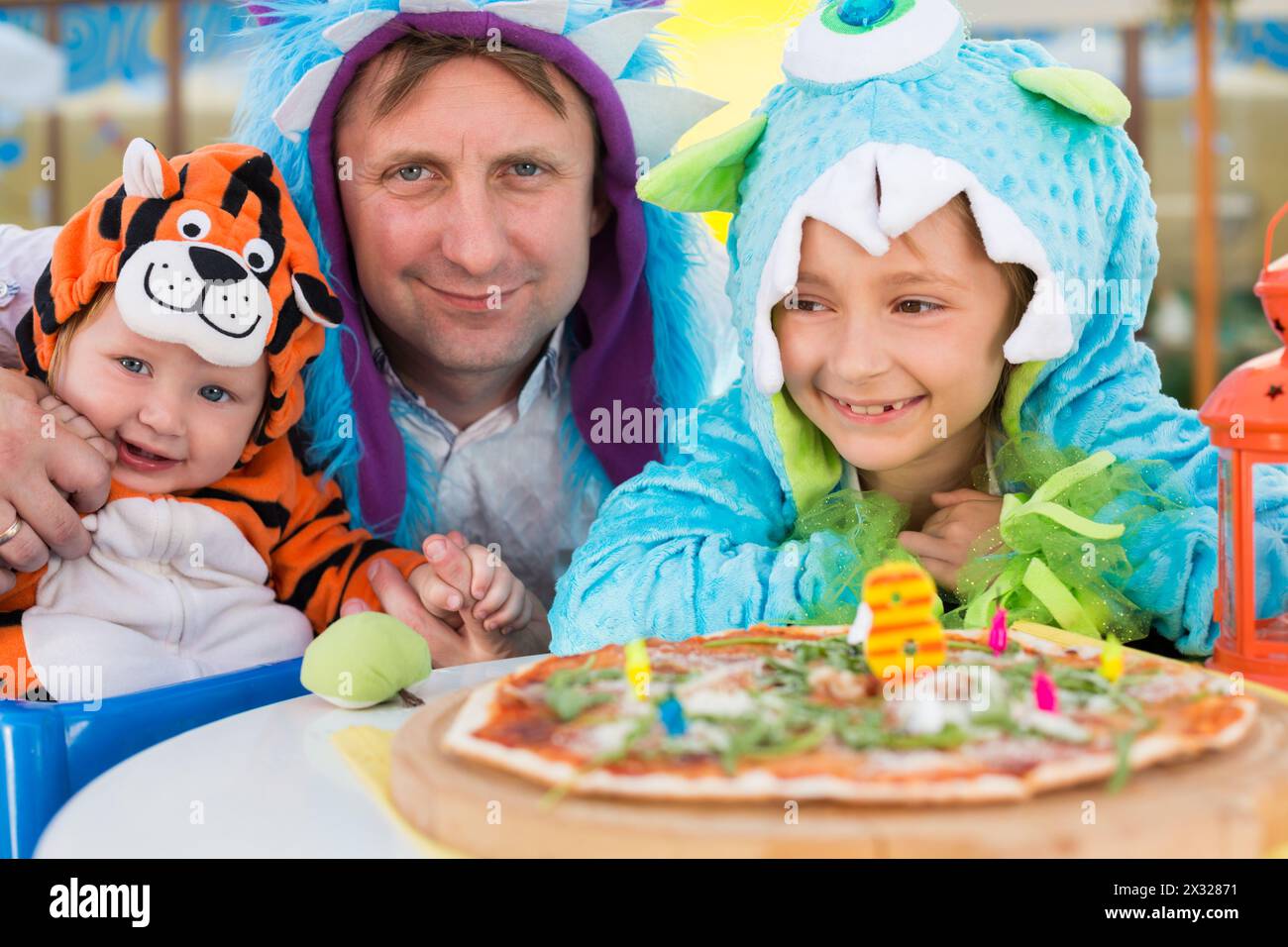 Father with daughter in monster costumes and baby boy in tiger costume ...