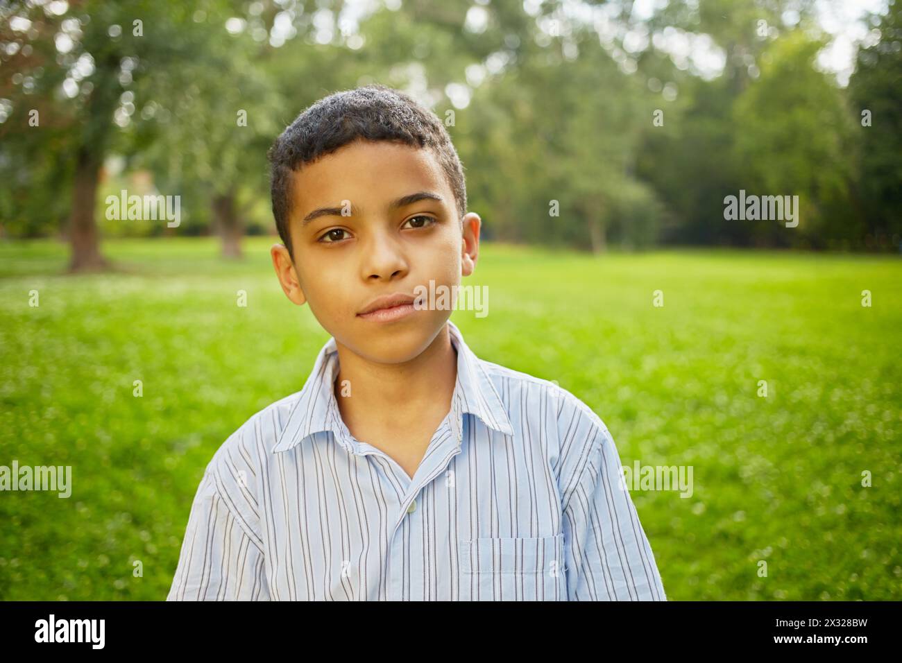 Closeup portrait of mulatto boy in light-blue striped shirt Stock Photo ...