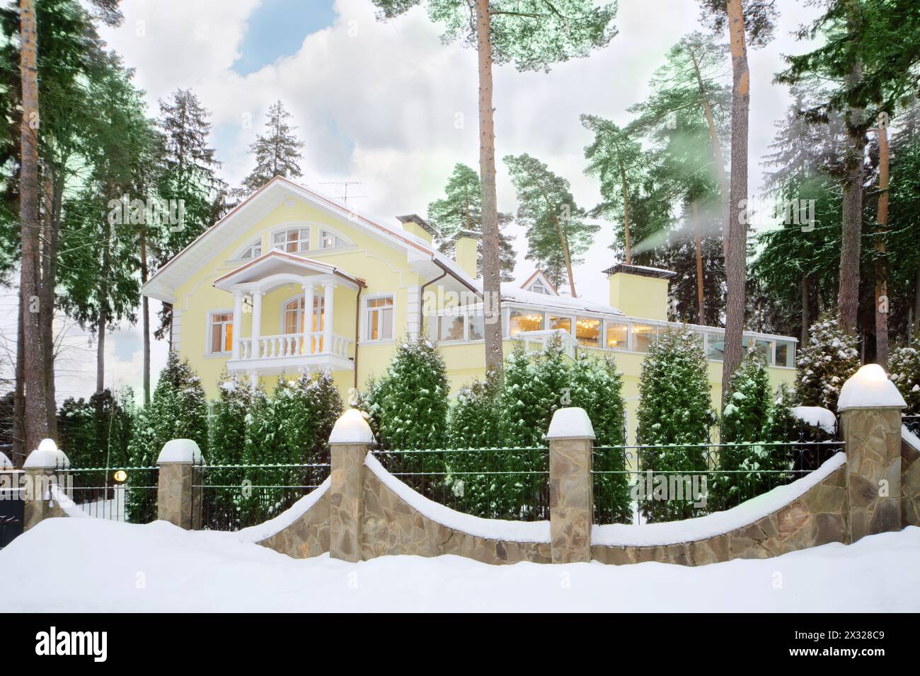 Yellow two-storey cottage among pines and firs at winter day Stock ...