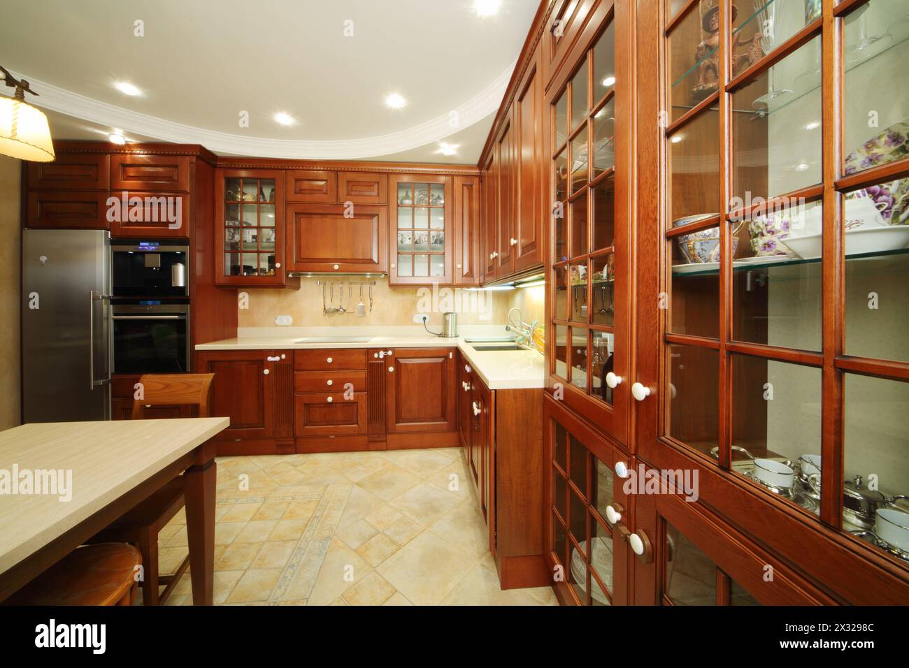 Kitchen with wooden furniture, integrated oven and fridge and cupboard ...