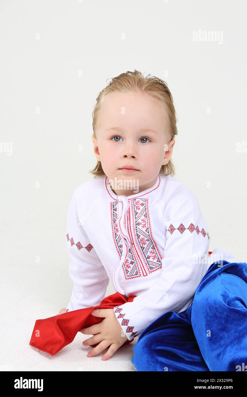 Little cute boy in Russian national costume sits on floor on white ...