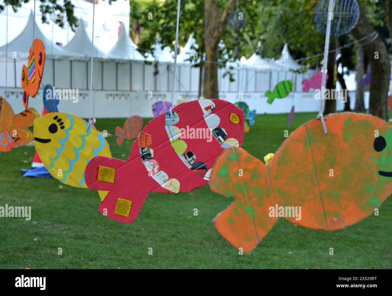 Pink painted cardboard fish hanging from a rope in a playground Stock ...
