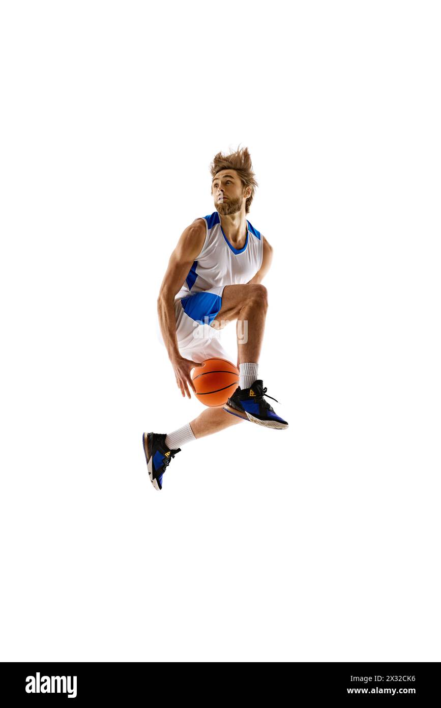 Slam dunk. Young, focused man, basketball player in motion, leaps a ...