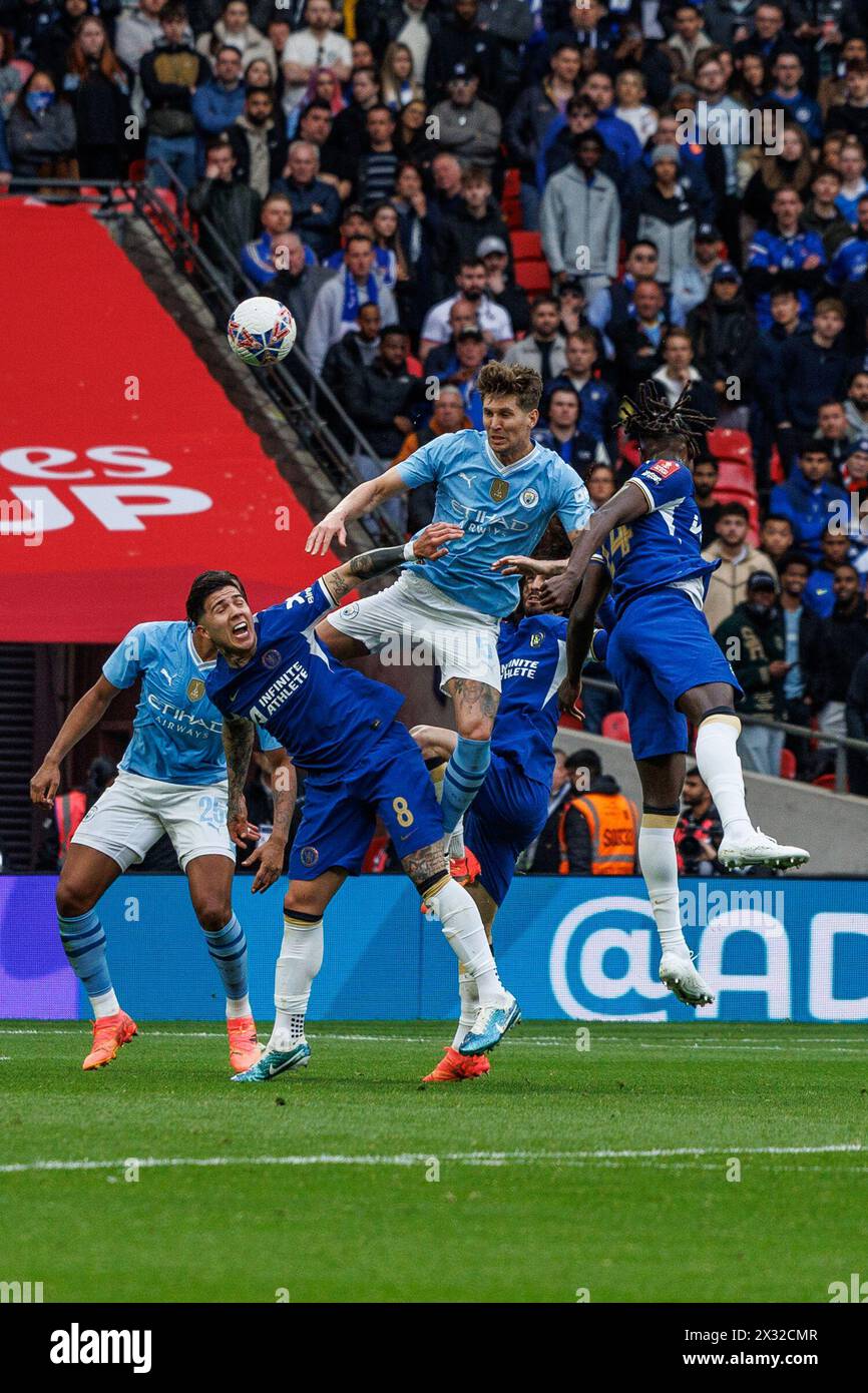 John Stones of Manchester City heading away under pressure from Enzo ...
