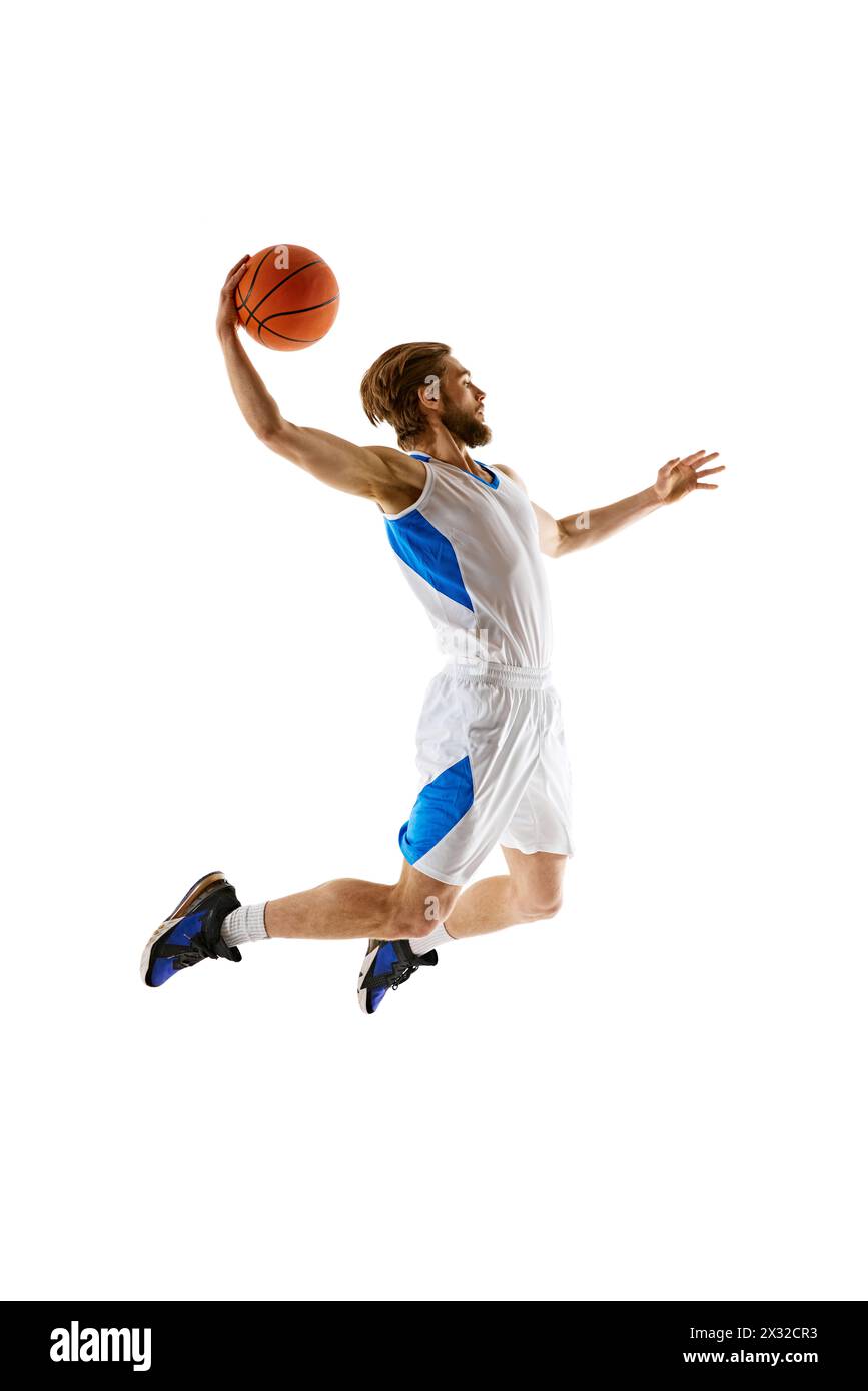 Young man, focused basketball player in motion, jumping and throwing ...