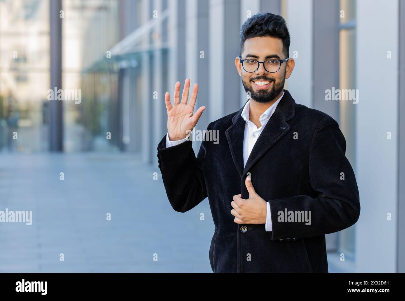 Hello. Indian businessman smiling friendly at camera, waving hands ...