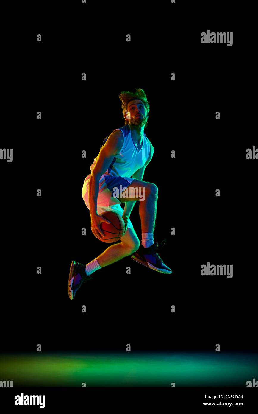 Slam dunk pose. Young, focused man, basketball player in motion ...