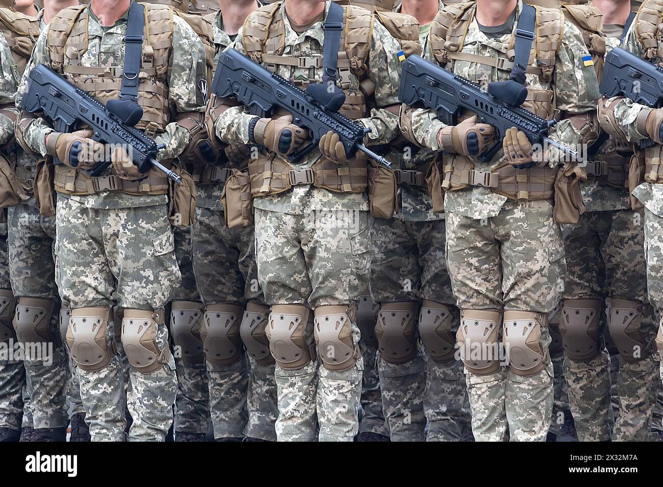 A line of soldiers in camouflage uniforms with a machine gun and ...