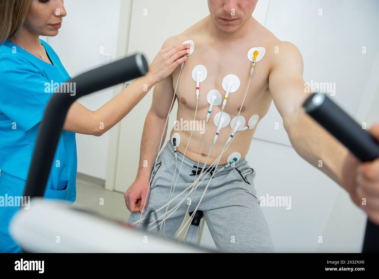 A patient undergoing a cardiac test with electrodes attached to their ...