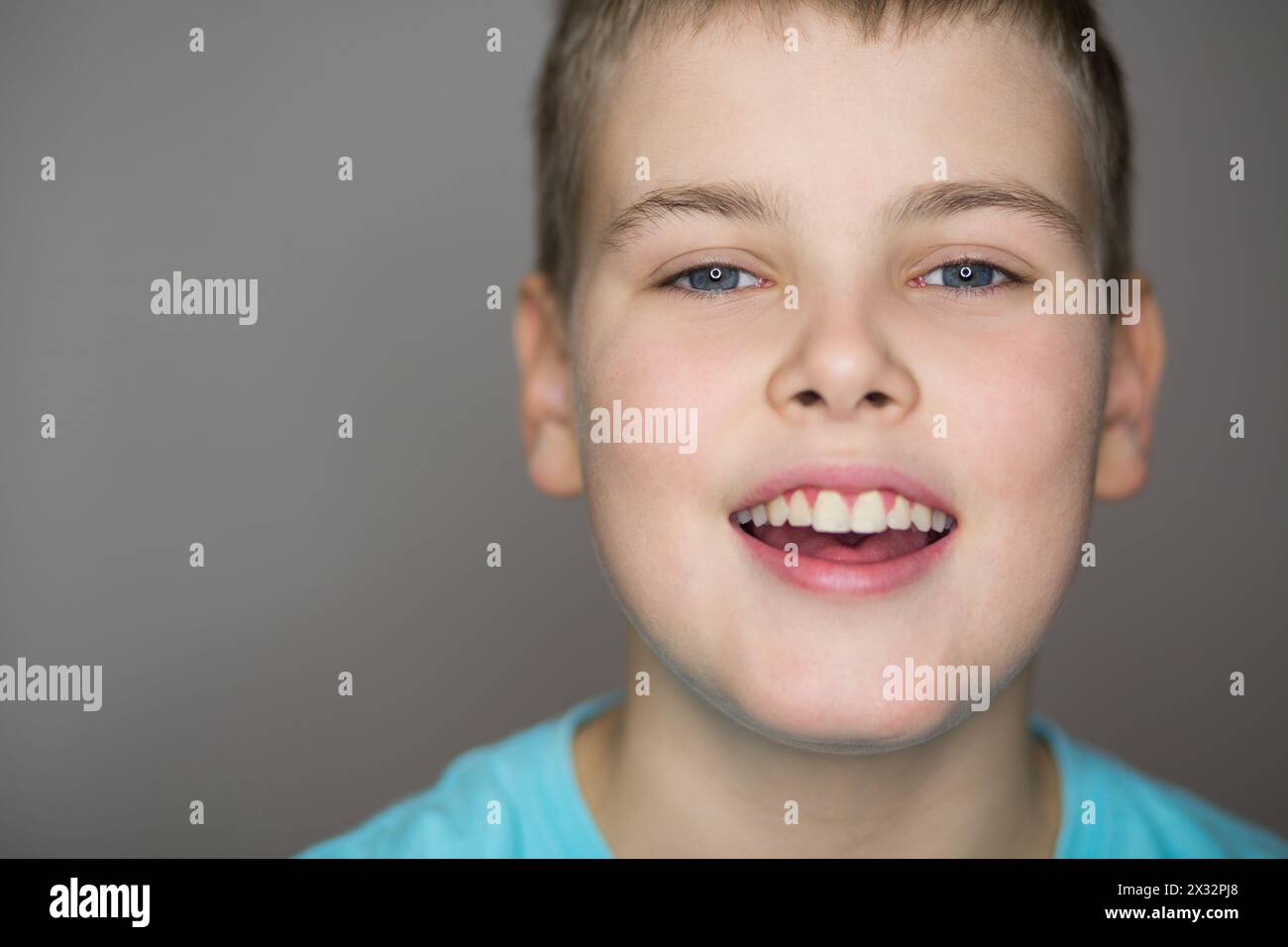 Portrait of smiling teen boy in blue T-shirt in studio Stock Photo - Alamy