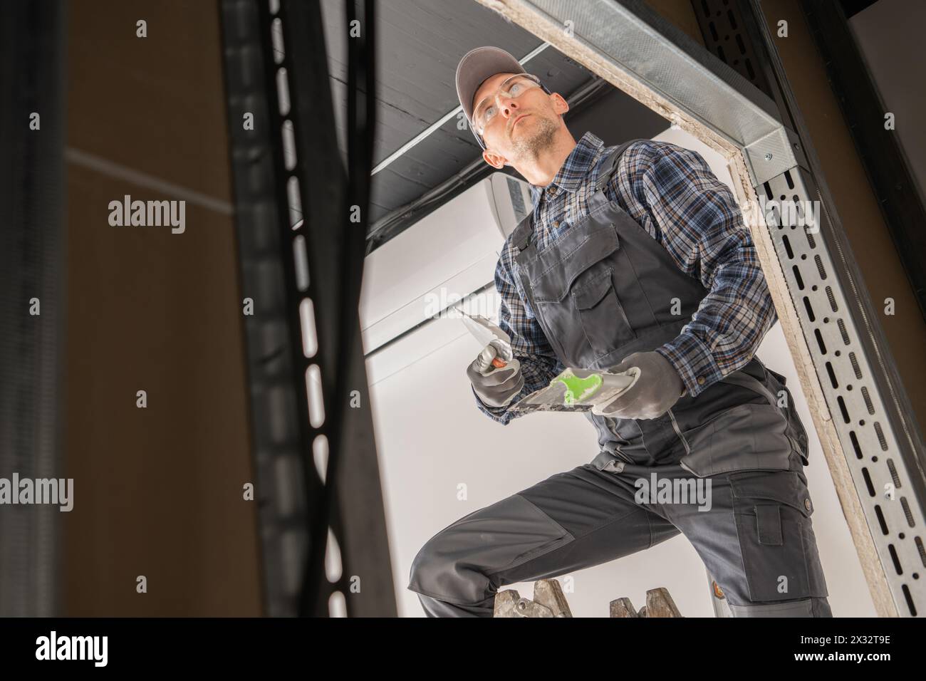 Caucasian Construction Site Worker Patching a Drywall. Interiors ...