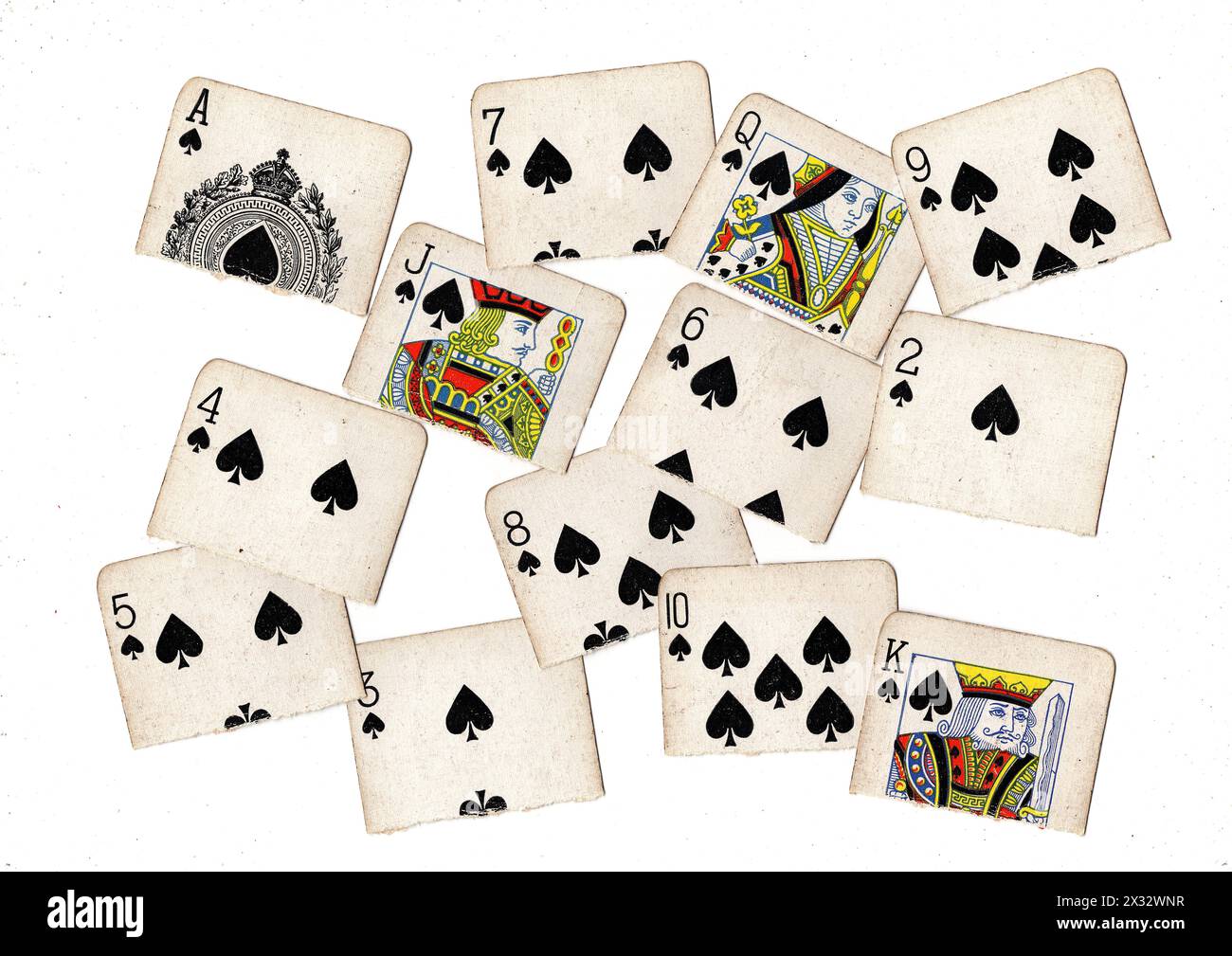 A montage of vintage spades playing cards torn in half on a white ...