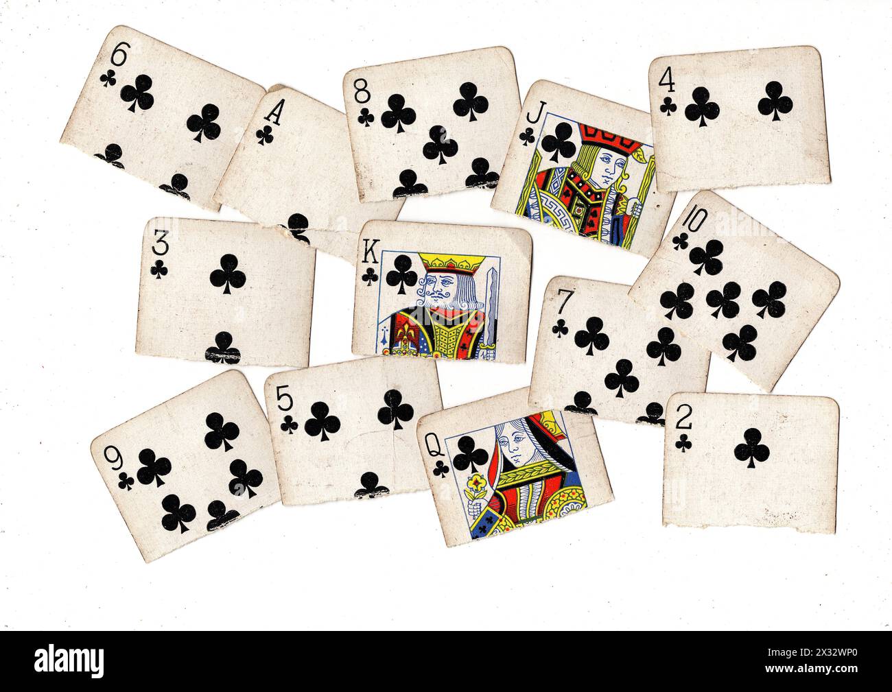 A montage of vintage clubs playing cards torn in half on a white ...
