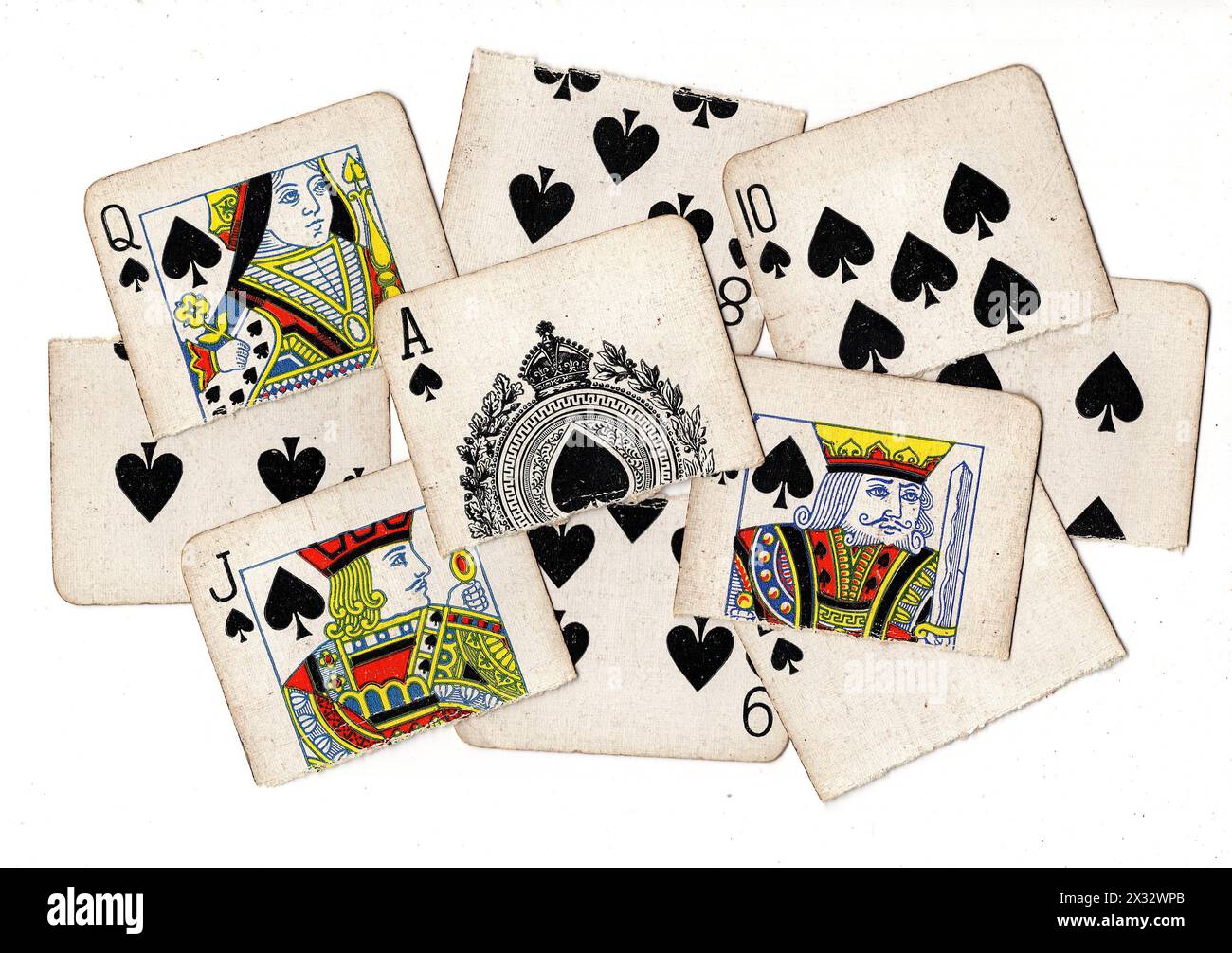 A montage of vintage spades playing cards torn in half on a white ...