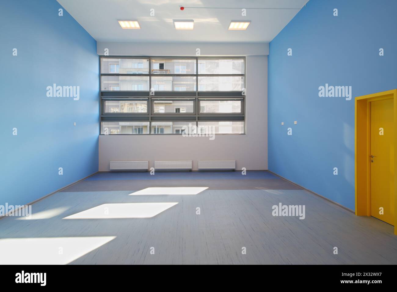 Group room with blue walls and large windows in the kindergarten Stock ...