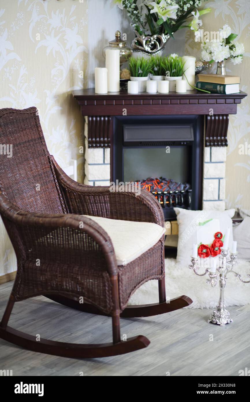 Wicker rocking chair, candlestick and fireplace with candles and ...