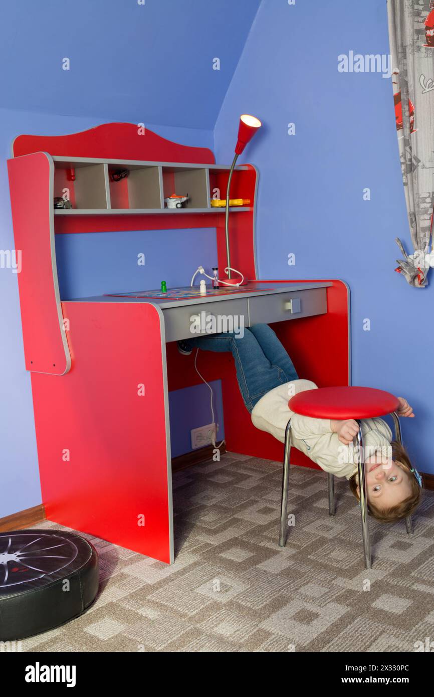 Little girl in children room under the chair at inverted house Stock ...