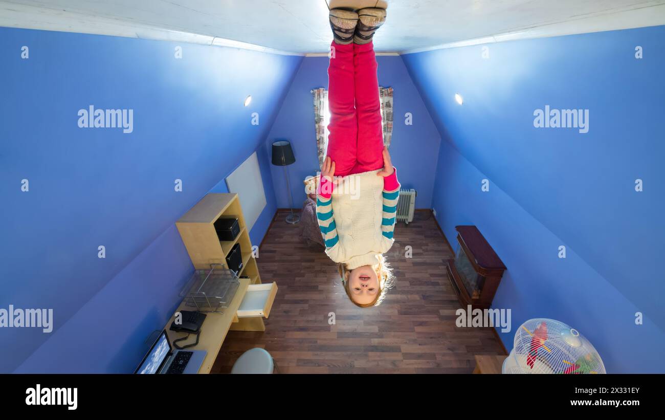 Little girl in jeans stands on the ceiling upside down at inverted ...