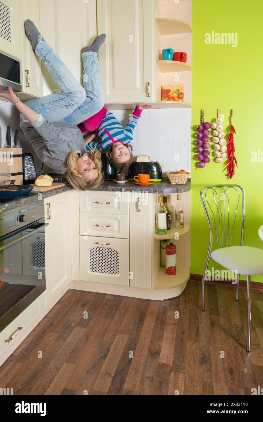 Mother and daughter sitting on kitchen floor hi-res stock photography ...