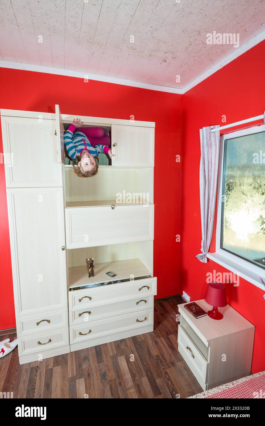 Little girl upside down in open closet at inverted house Stock Photo ...