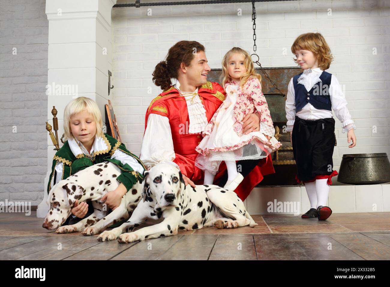 Father in medieval costume with three children and three dalmatians sit ...