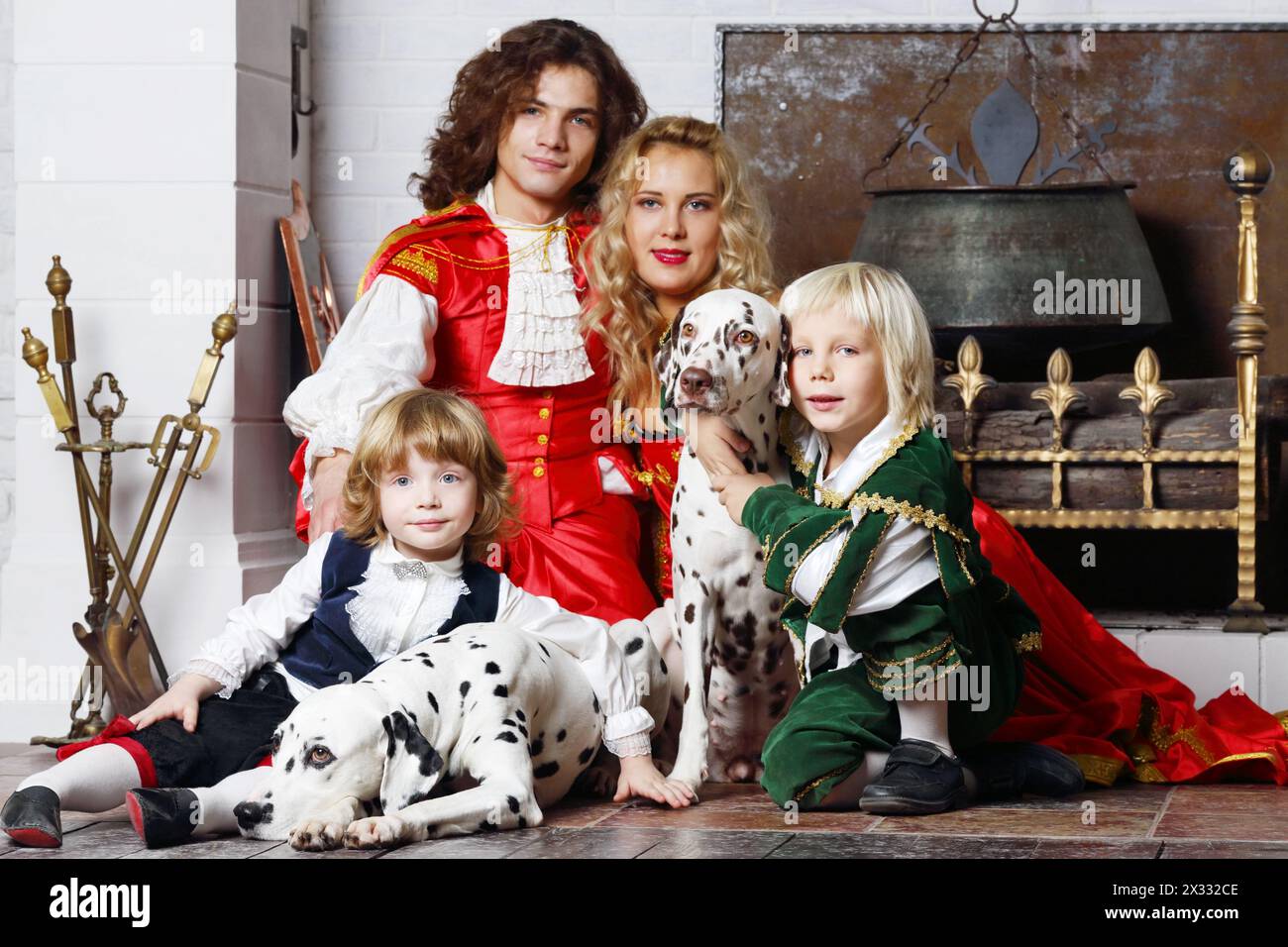 Happy father, mother and two sons in medieval costumes sit with two ...