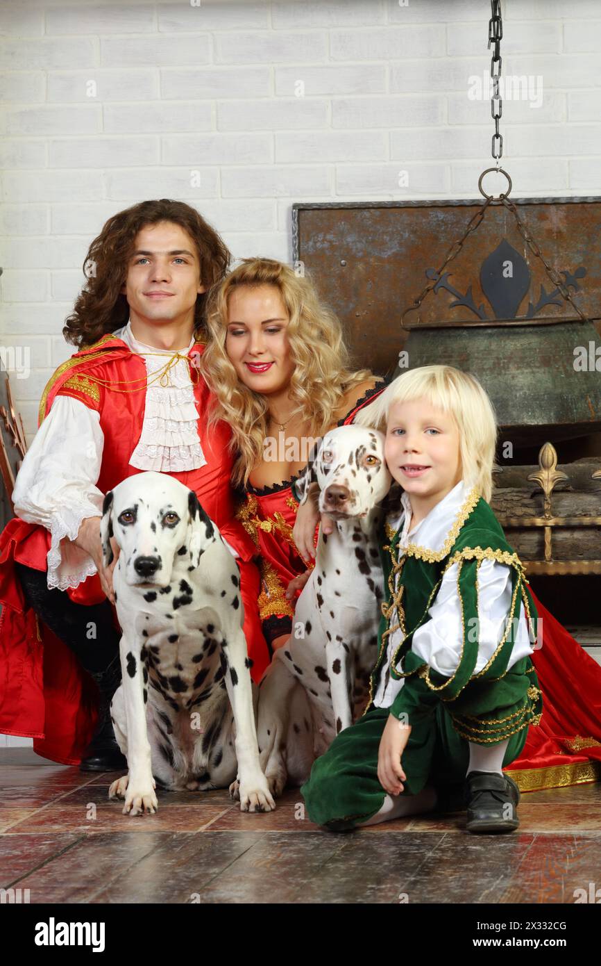 Happy father, mother and son in medieval costumes sit with two ...
