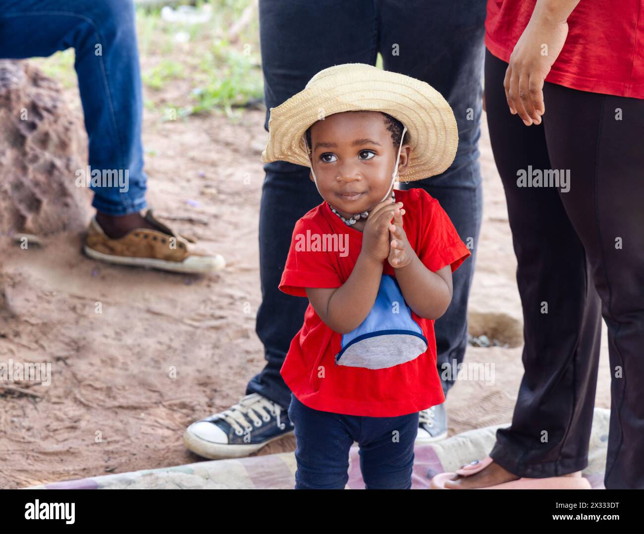 small african child girl in front of the house in the yard, wearing a ...