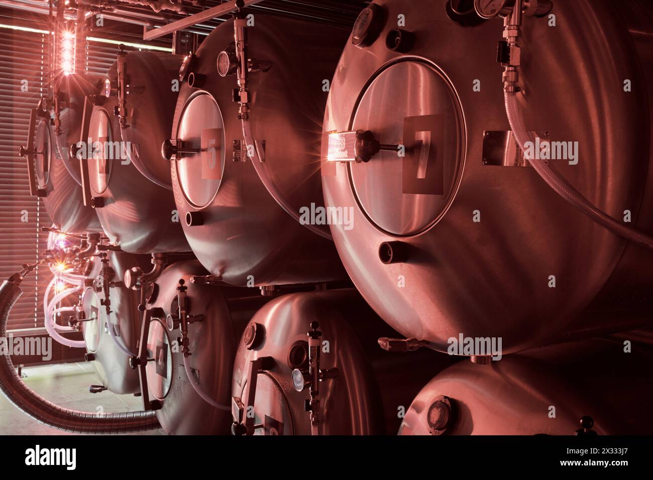Horizontal tanks at brewery in red light Stock Photo - Alamy