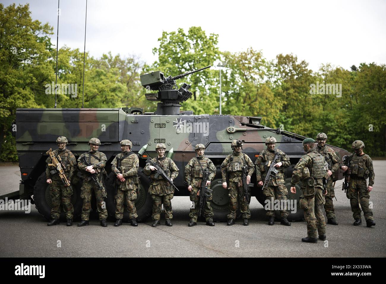 Soldiers of the German forces, Bundeswehr, stand in front of a Boxer ...
