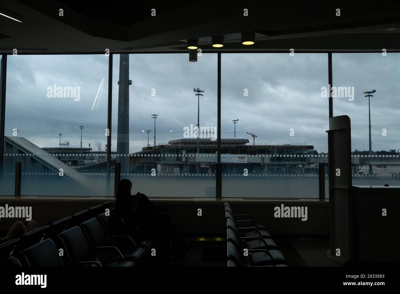 Silhouette of a woman waiting at the boarding gate of Terminal 1, Paris ...