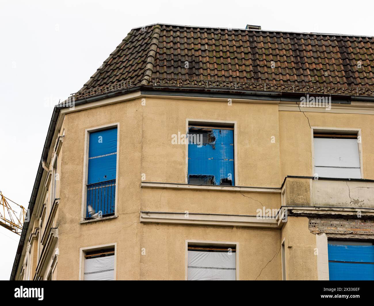 Old building exterior with cracks in the wall and broken windows ...