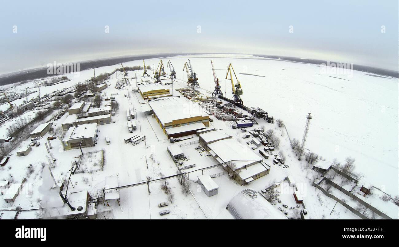 Aerial view to empty cargo dock with cranes and containers on frozen ...