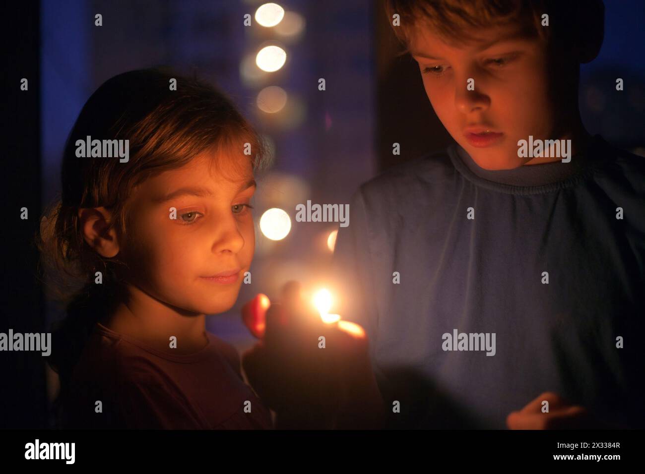girl and boy look at a burning candle Stock Photo - Alamy