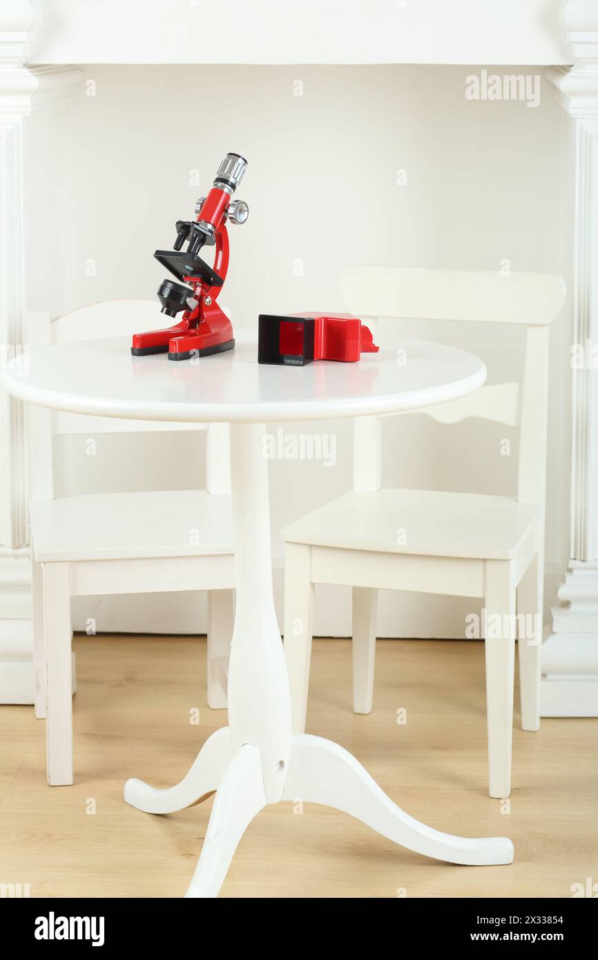 White table with red microscope and two childrens chairs Stock Photo ...