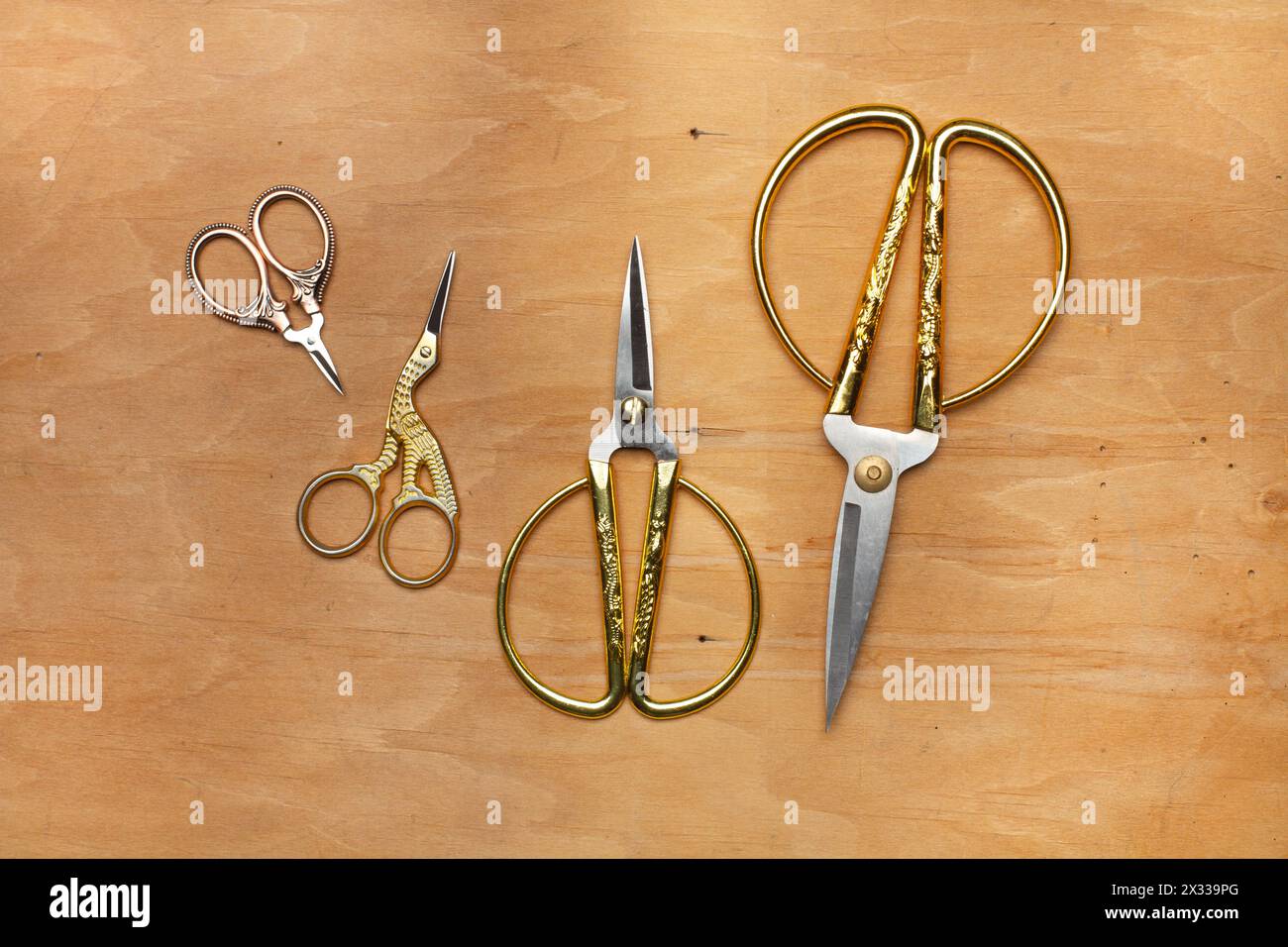 Four different types of scissors on a wooden background in a top view ...