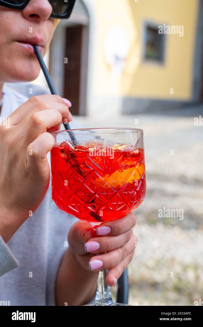 Drinking of Spritz Campari red bitter long drink cocktail maid with ...