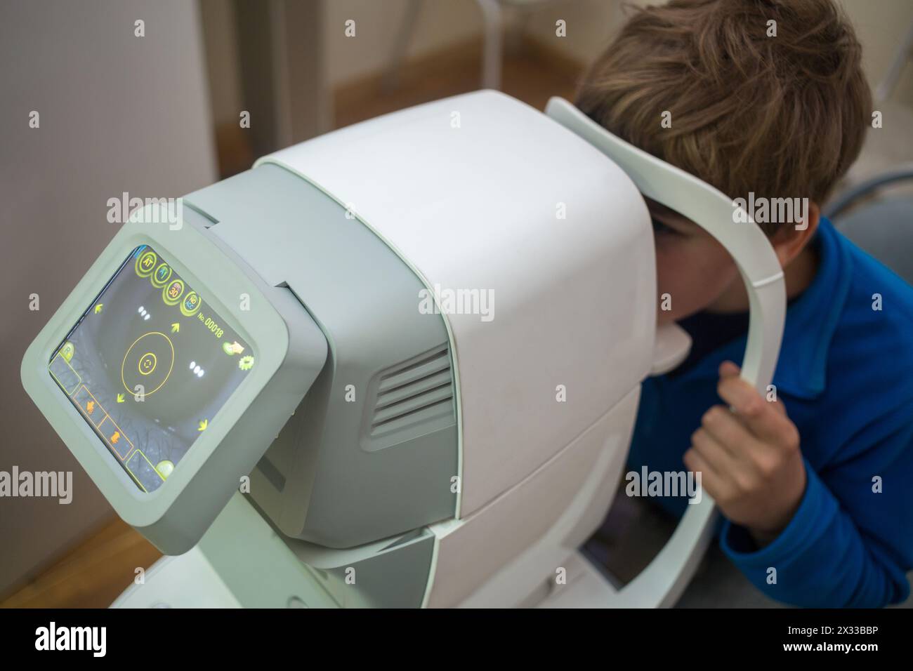 boy tests his eyes at Auto-Ref-Keratometer Stock Photo - Alamy