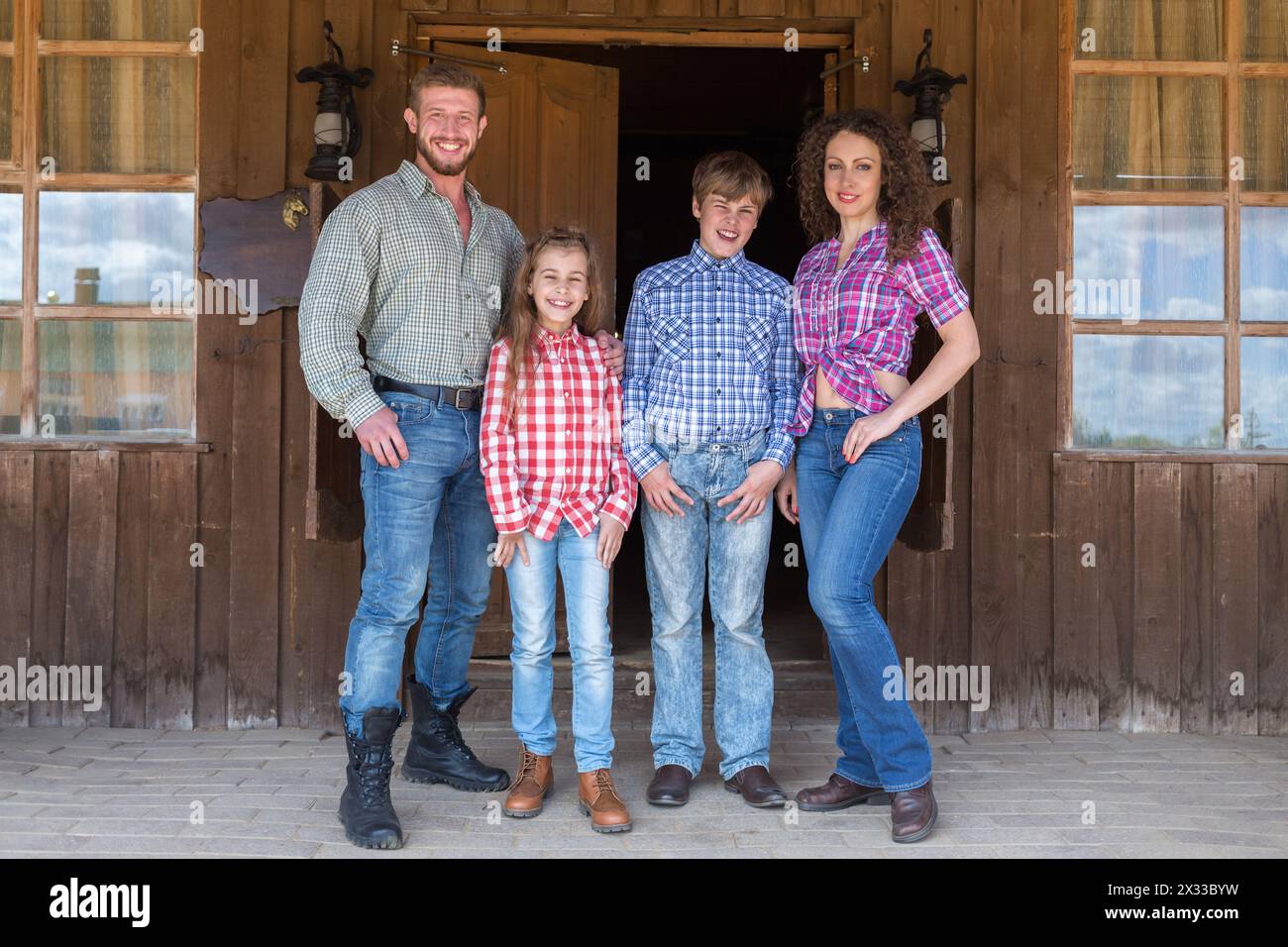 family of four standing on terrace of wild west saloon Stock Photo - Alamy