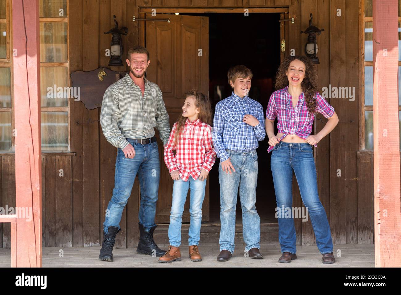 family of four posing on terrace of wild west saloon Stock Photo - Alamy