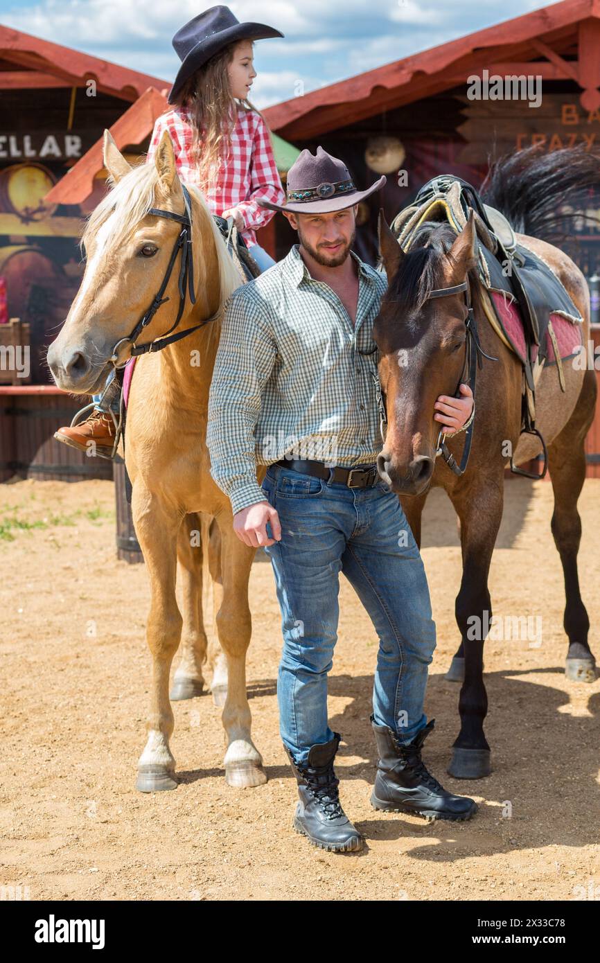 cowboy father and daughter with horses Stock Photo - Alamy