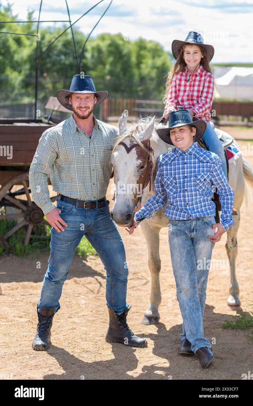 cowboy father with son and daughter on a horse Stock Photo - Alamy